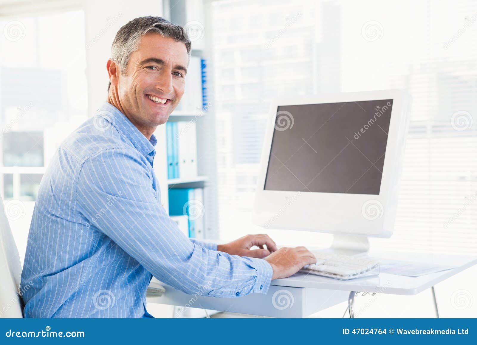 Smiling Man Typing on Keyboard and Looking at Camera Stock Photo ...