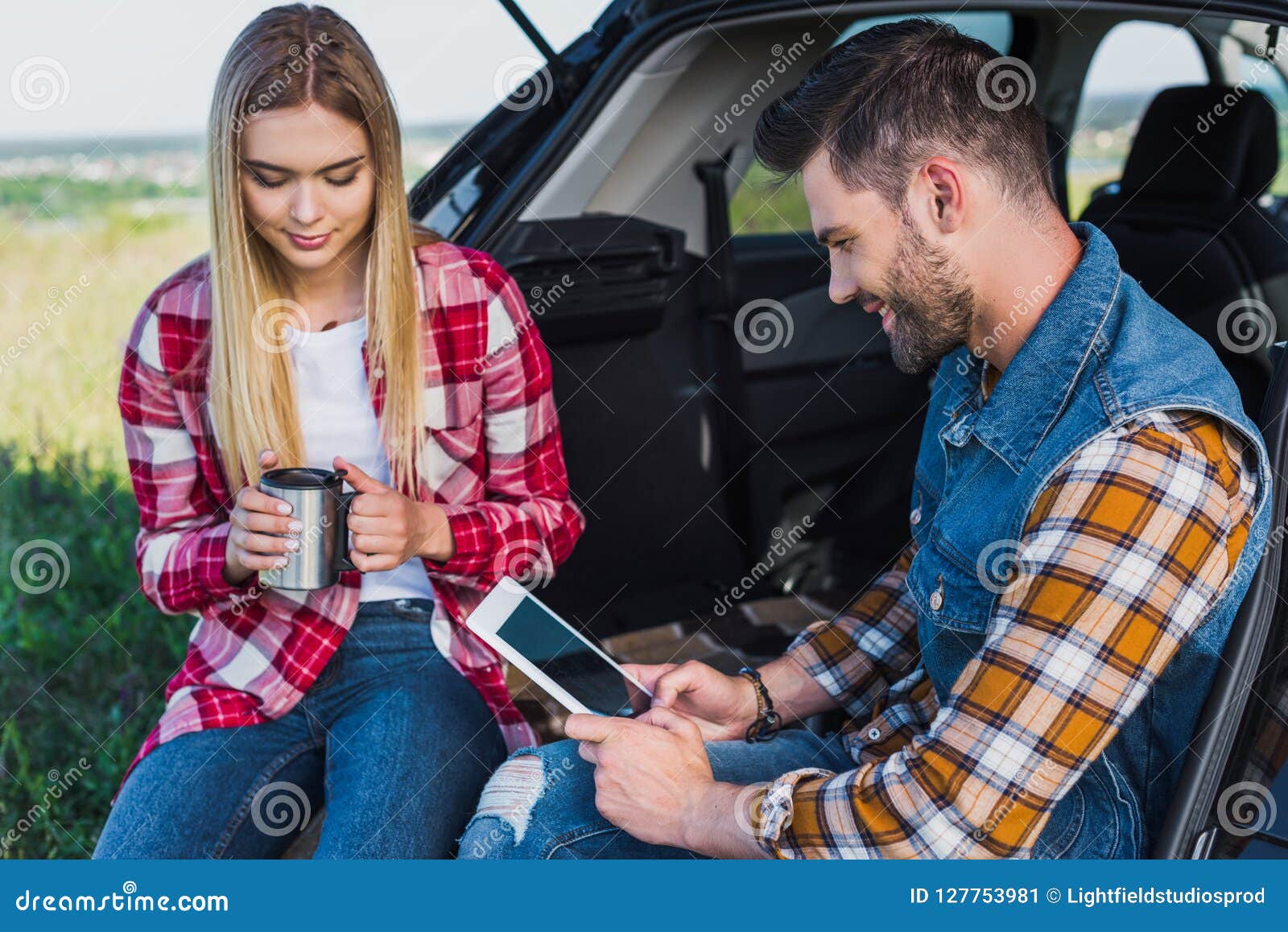 Smiling Man Using Digital Tablet with Blank Screen while His Girlfriend ... Smiling Man Using Digital Tablet with Blank Screen while His Girlfriend ...