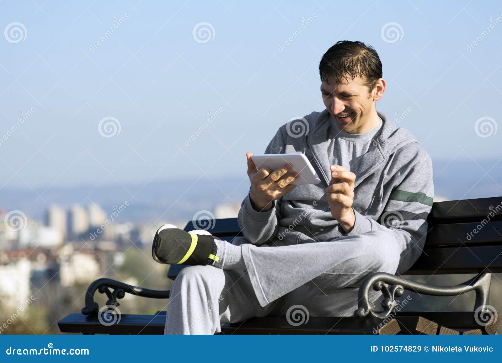 Smiling man using tablet stock image. Image of park - 102574829 Smiling man using tablet stock image. Image of park - 102574829