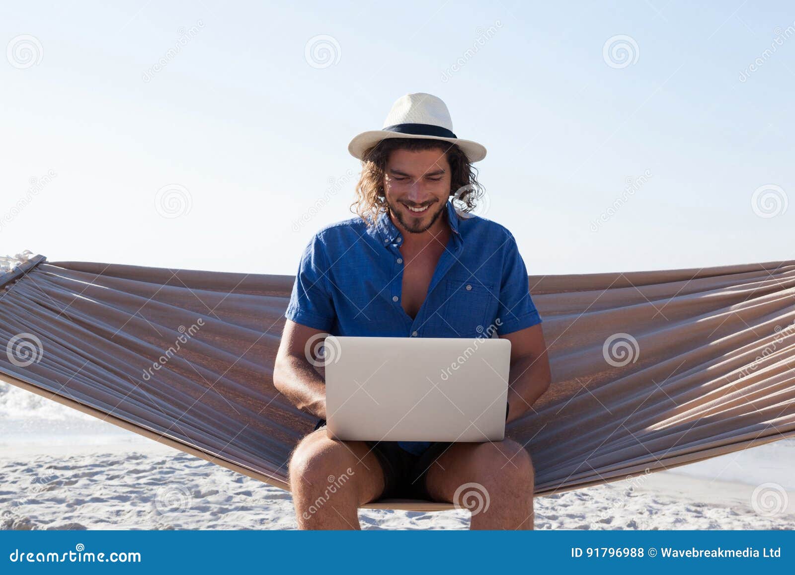 Smiling Man Using Laptop while Sitting on Hammock at Beach Stock Photo ...