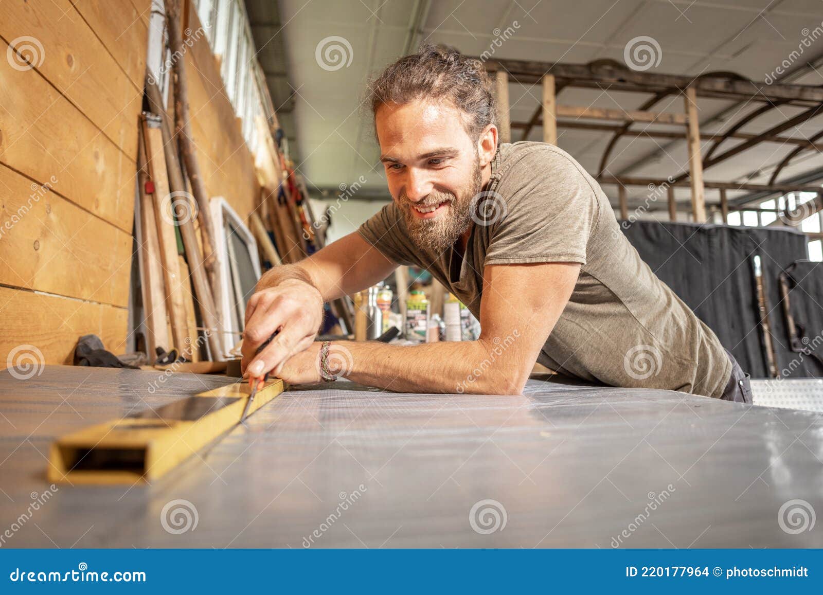Smiling Man Working with a Cutter Knife on a Workbench Stock Photo ...