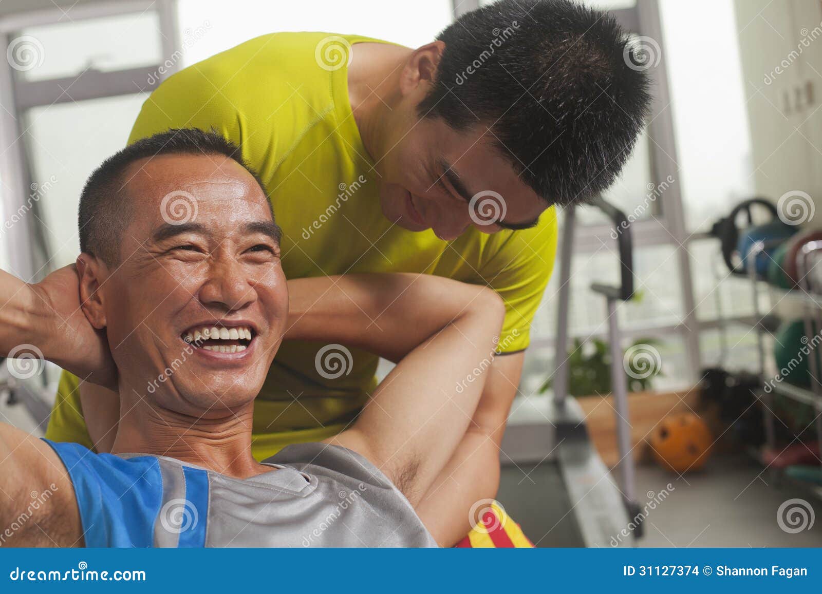 Smiling Man Working Out with His Trainer, Doing Sit Ups Stock Photo ...