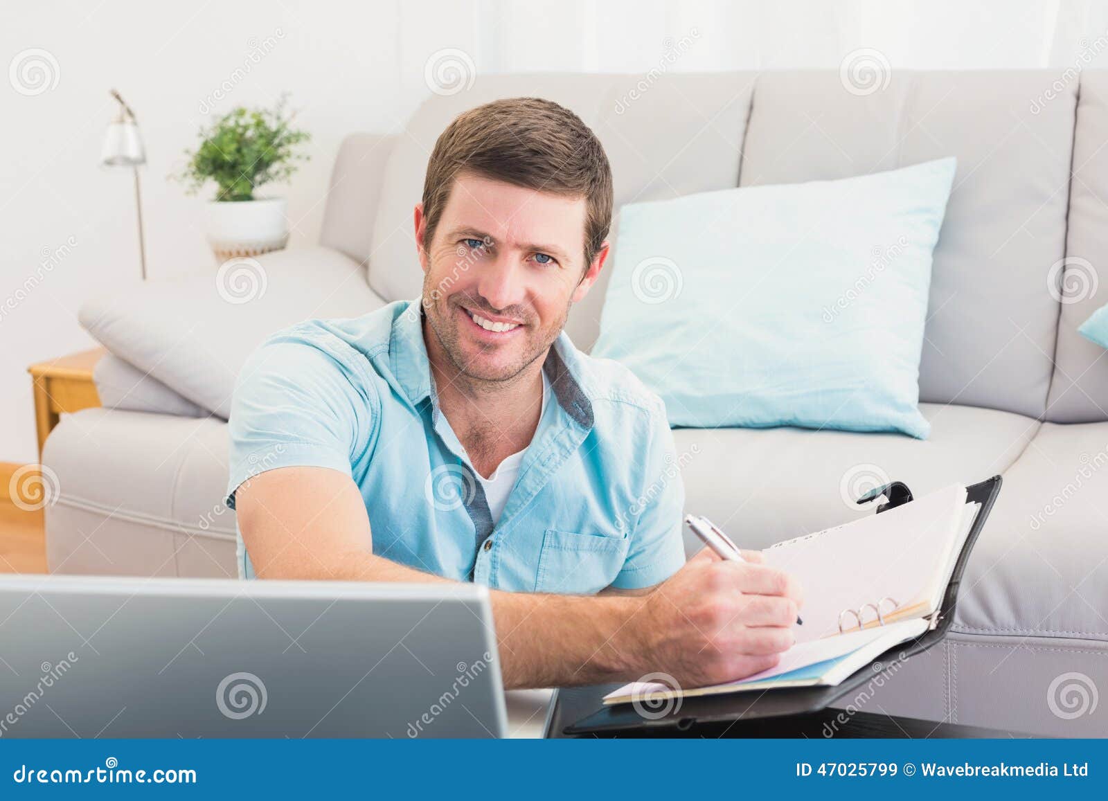 Smiling Man Writing on a Notebook Stock Image - Image of domestic ...