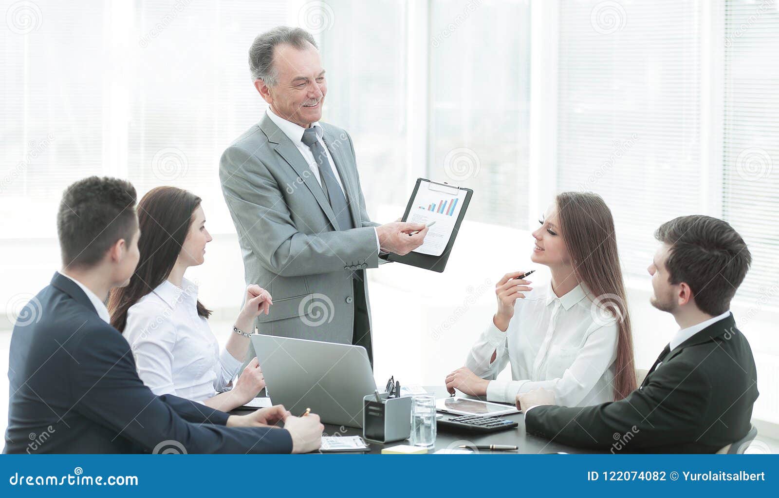 Smiling Manager Showing A Business Team A Graph With Financial Data