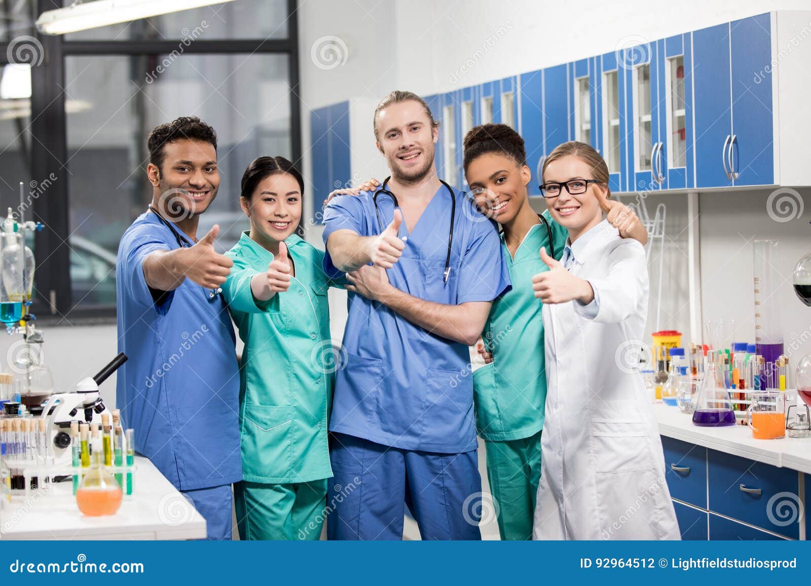Smiling Medical Workers Showing Thumbs Up in Laboratory Stock Photo ...
