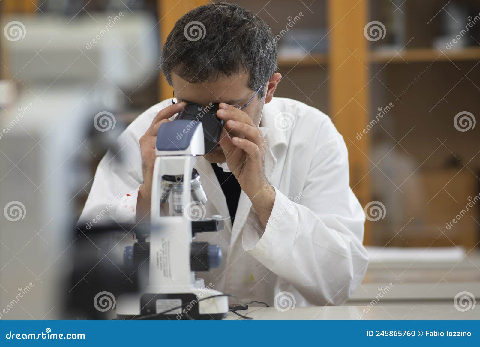 Smiling Microbiologist at Work into Laboratory Using a Microscope Stock ...