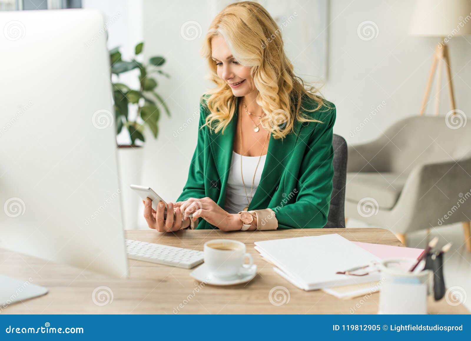 Smiling Middle Aged Businesswoman Using Smartphone and Desktop Computer ...
