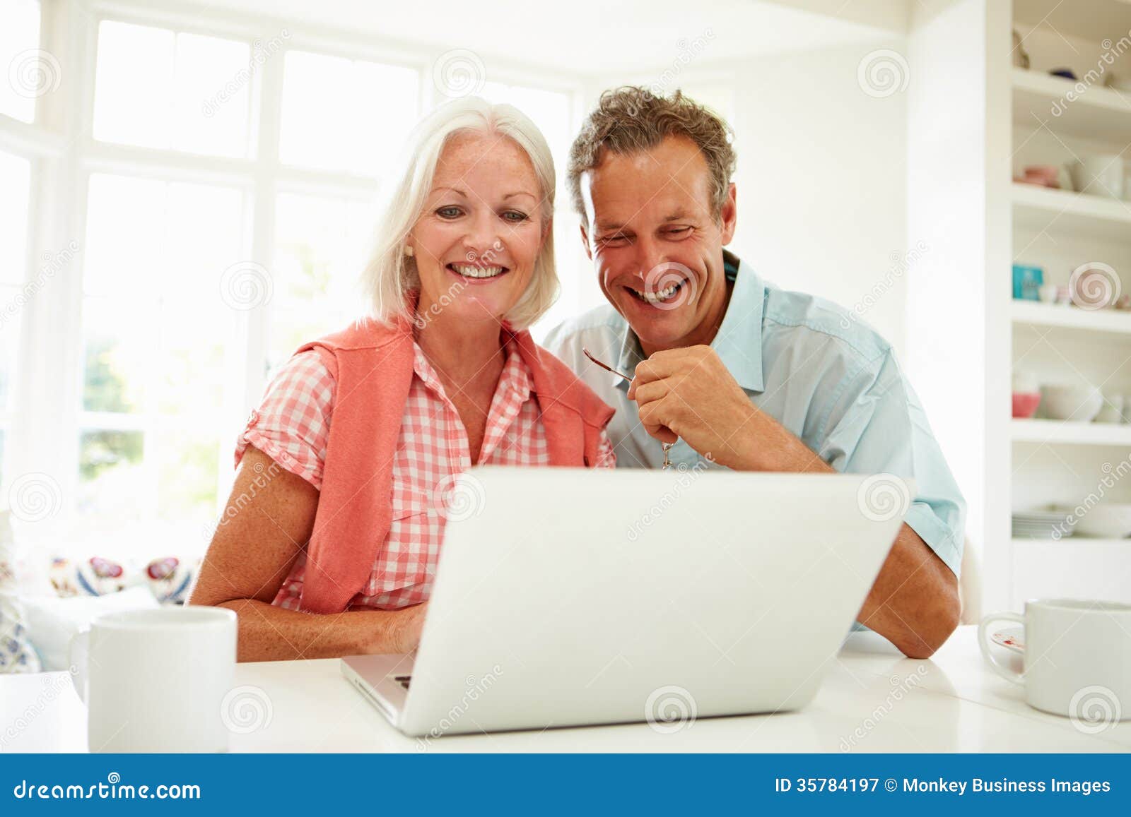Smiling Middle Aged Couple Looking at Laptop Stock Image - Image of ...