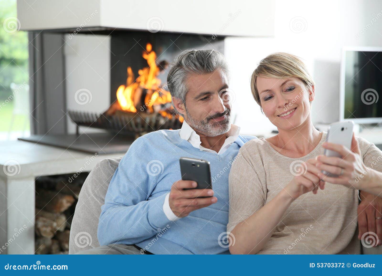 Smiling Middle-aged Couple Using Smartphones Stock Photo - Image of ...