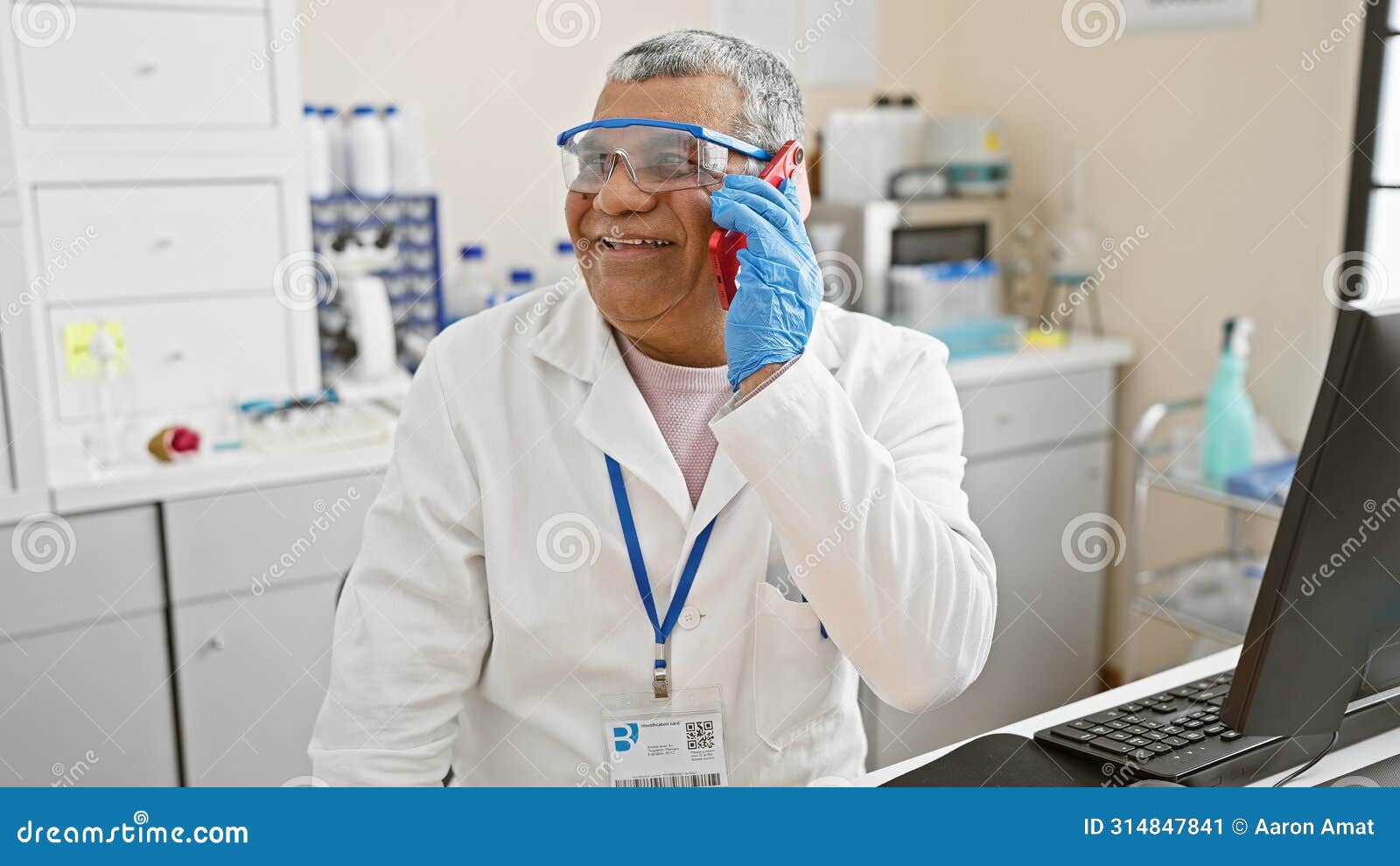 Smiling Middle-aged Man in Lab Coat Talking on Phone in Laboratory ...