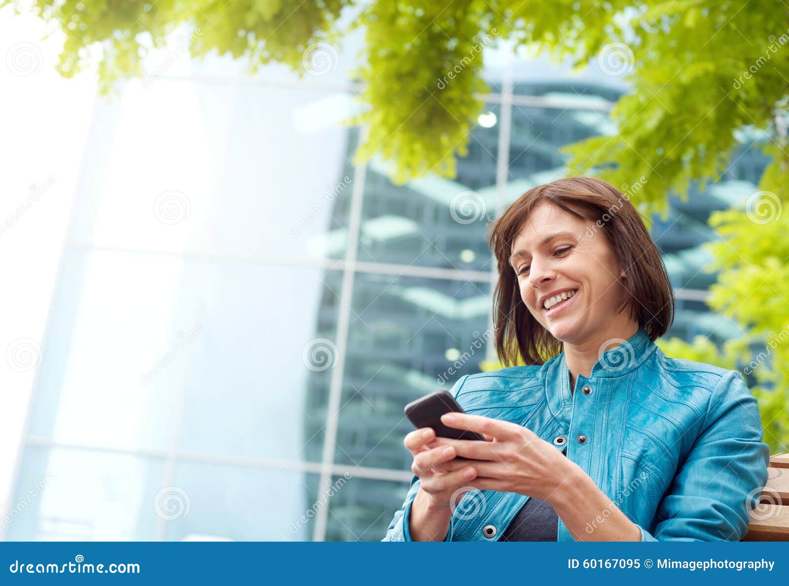 Smiling Middle Aged Woman Using Mobile Phone Outside Stock Image ...