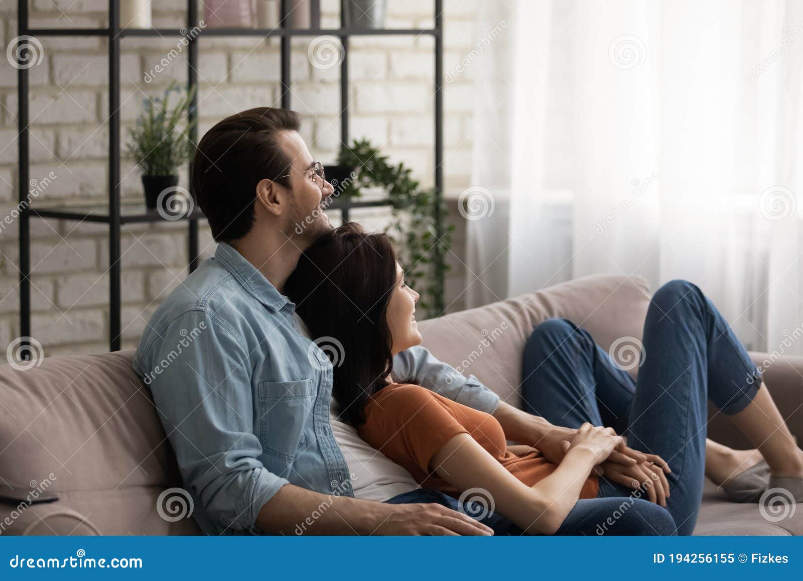 Happy Couple Relax Cuddle On Comfortable Sofa At Home Stock Image
