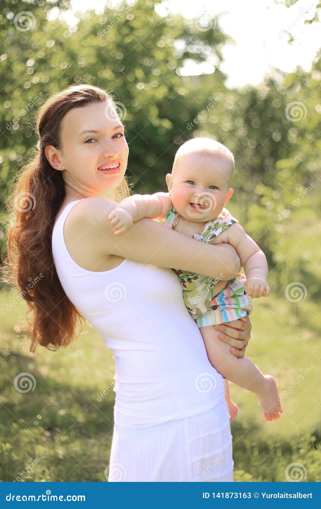 Smiling Mother And Happy One Year Old Daughter On A Walk In The Park