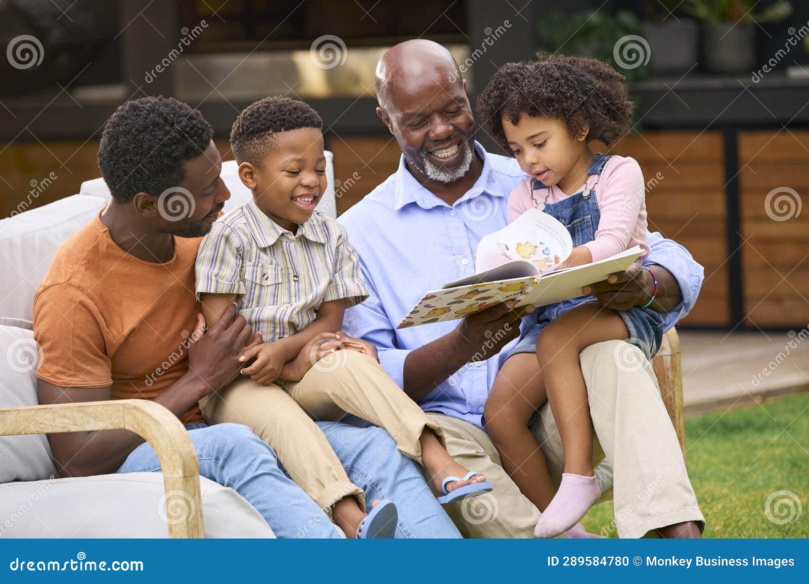 Smiling Multi-Generation Family Reading Book in Garden Together Stock ...