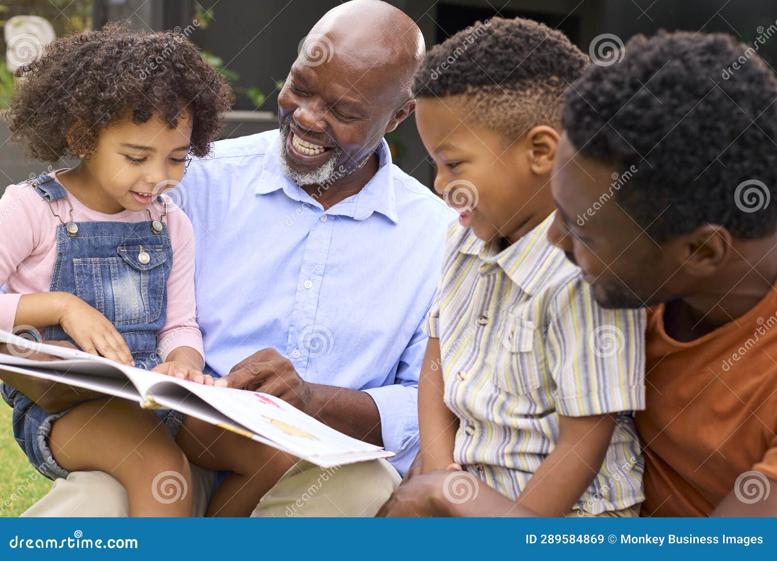 Smiling Multi-Generation Family Reading Book in Garden Together Stock ...