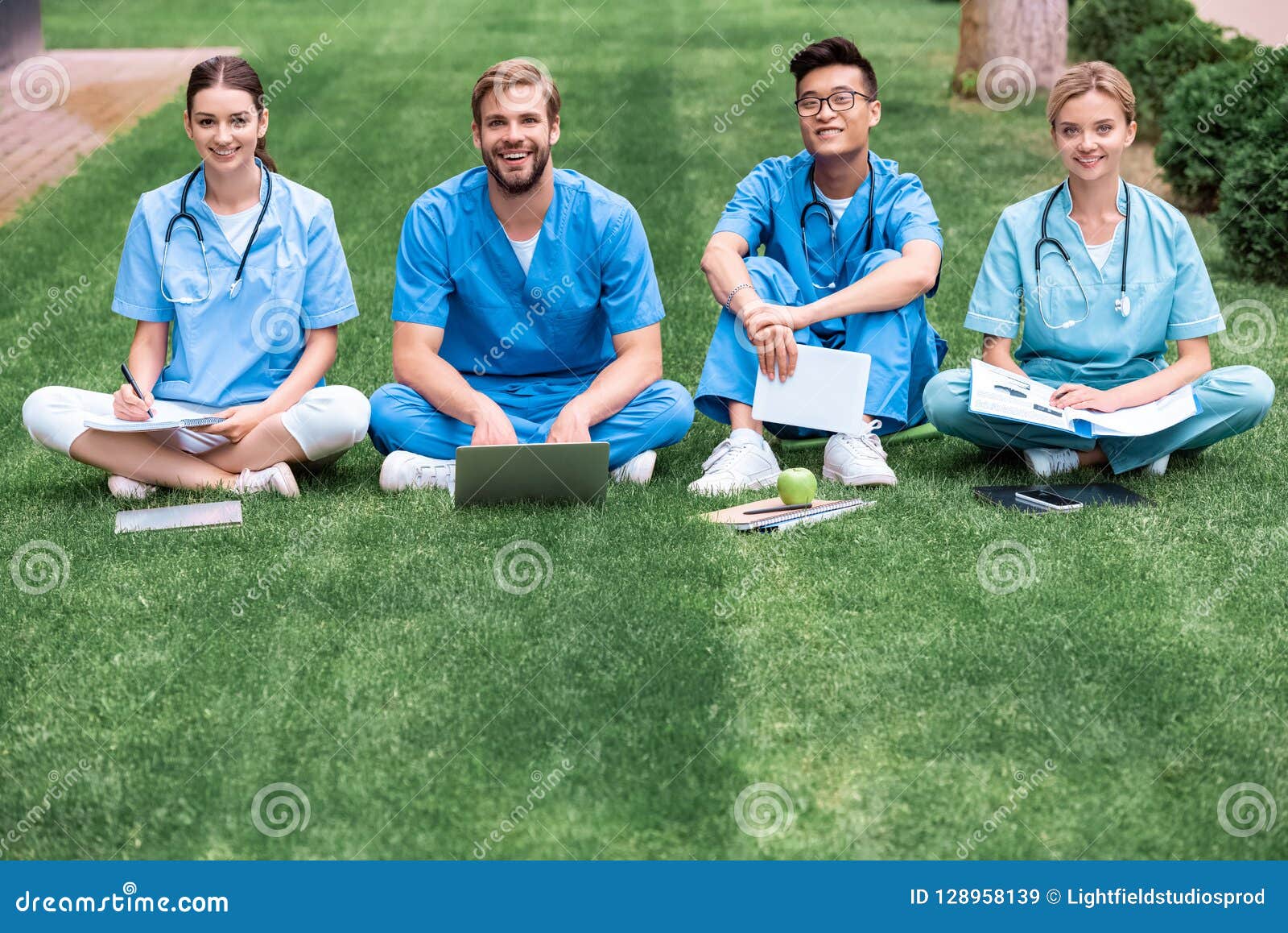 Smiling Multicultural Medical Students Sitting on Grass and Looking ...