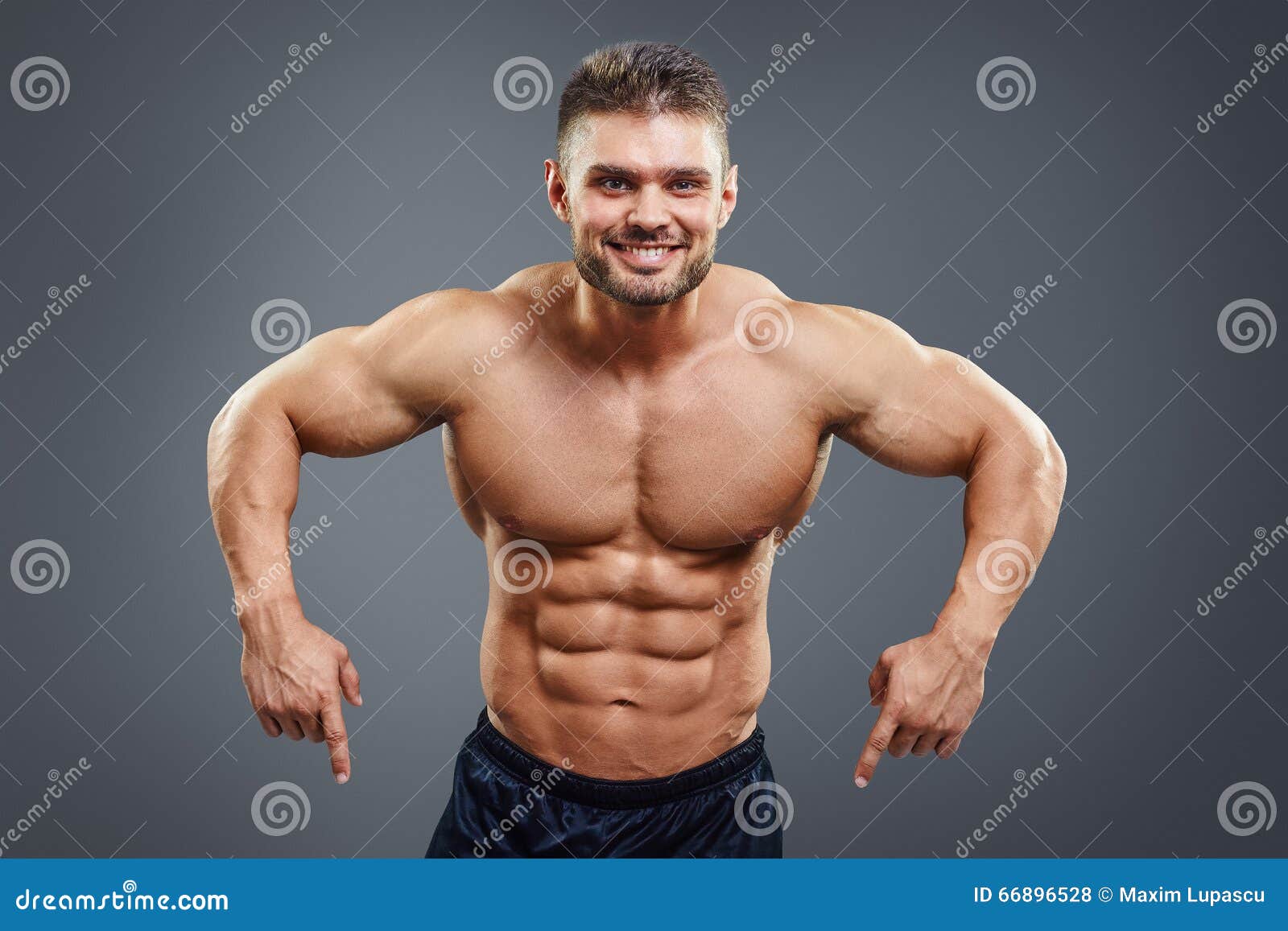 Smiling Muscular Man Pointing Down Stock Photo - Image of success ...