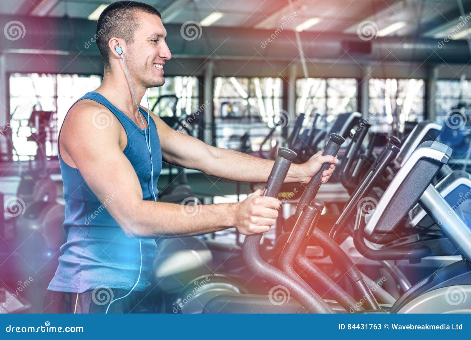 Smiling Muscular Man Using Elliptical Machine Stock Image - Image of ...