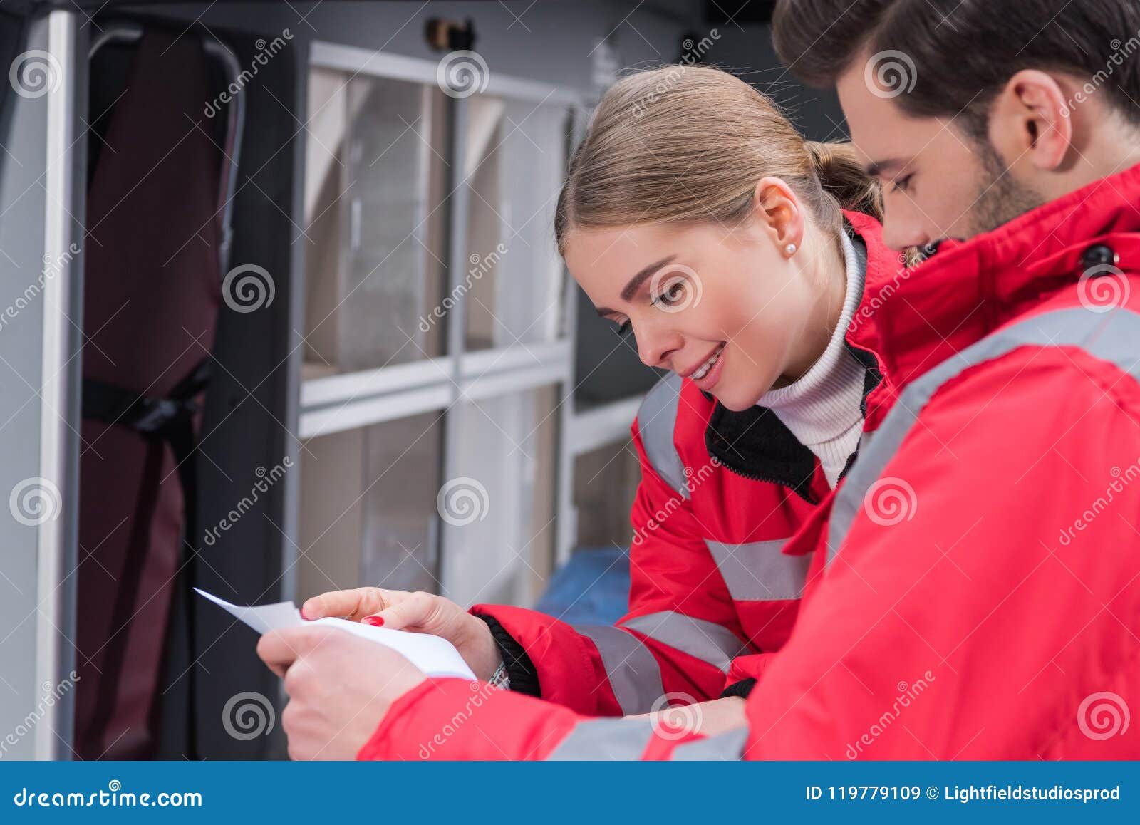 Smiling Paramedics Looking at Documents while Standing Stock Image ...