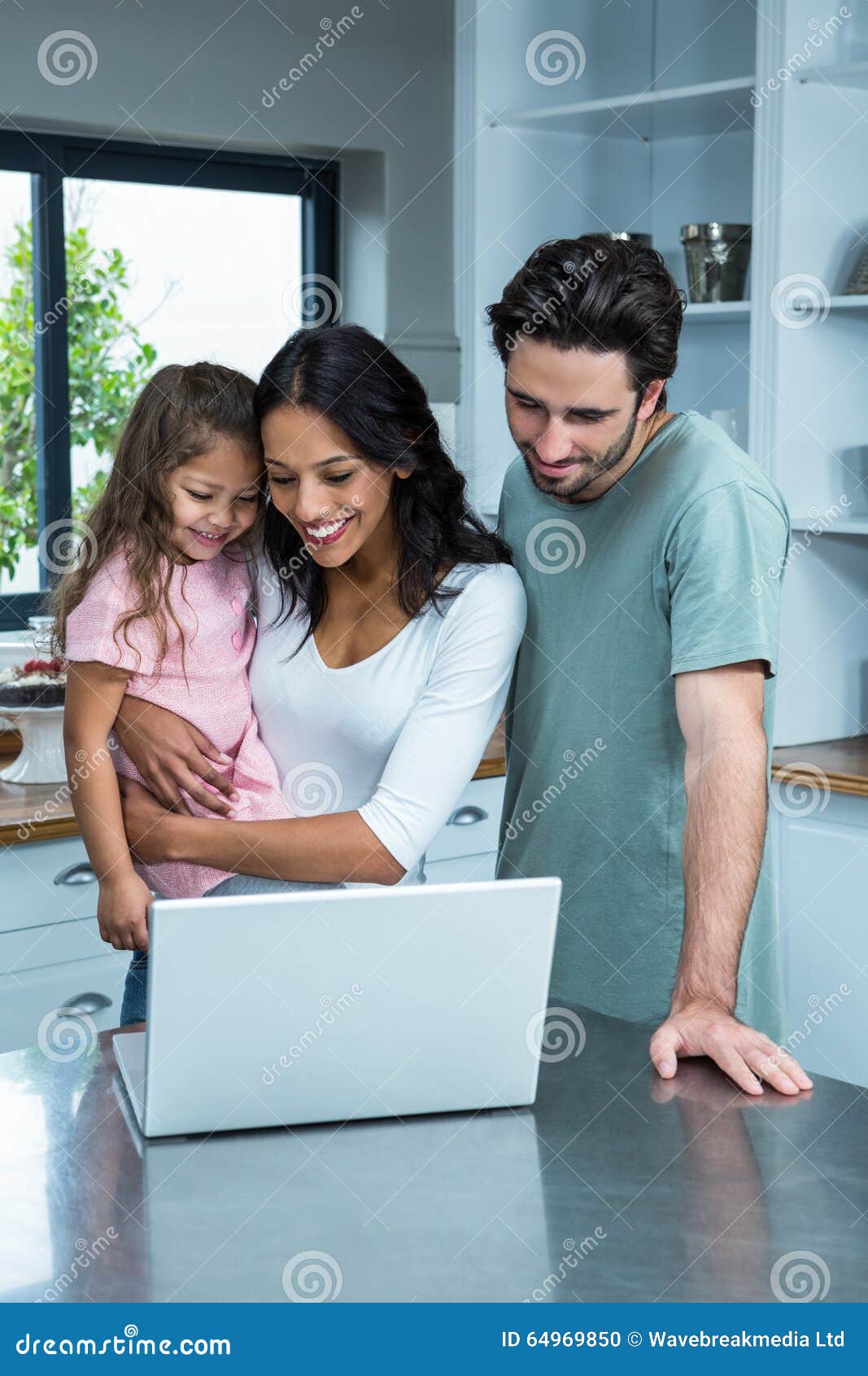 Smiling Parents Using Laptop with Daughter Stock Photo - Image of ...