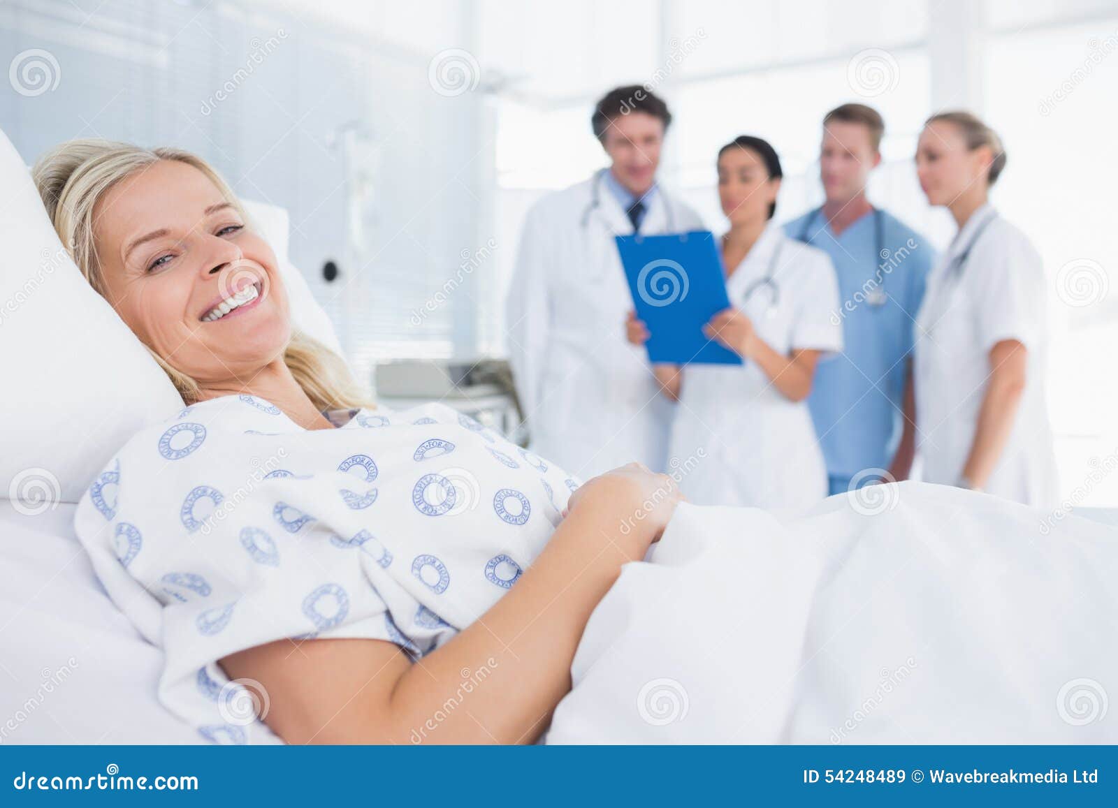 Smiling Patient Looking at Camera with Doctors Behind Stock Image ...