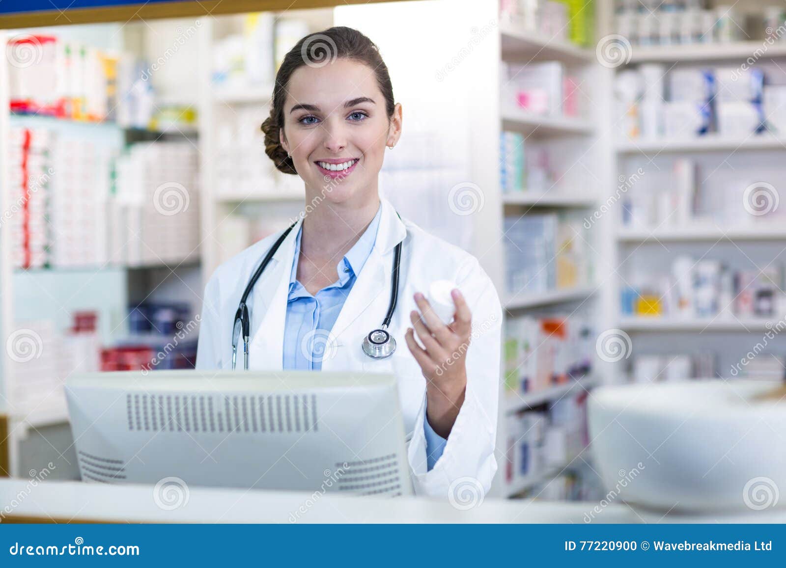 Smiling Pharmacist Holding Medicine Container in Pharmacy Stock Photo ...