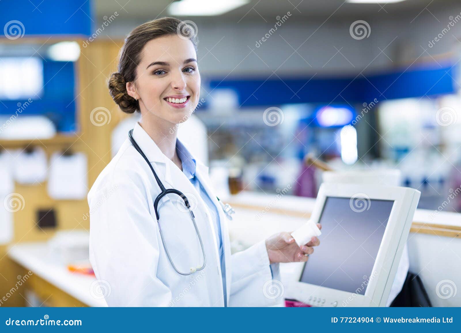 Smiling Pharmacist Holding Medicine Container in Pharmacy Stock Photo ...