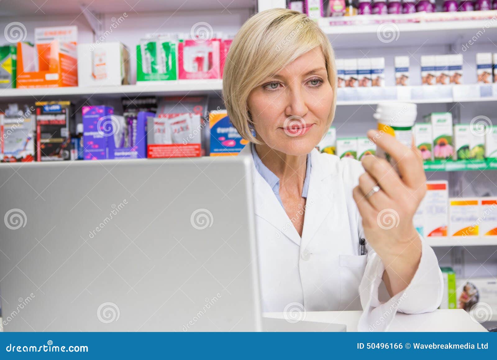 Smiling Pharmacist Looking at Medicine Stock Photo - Image of ...