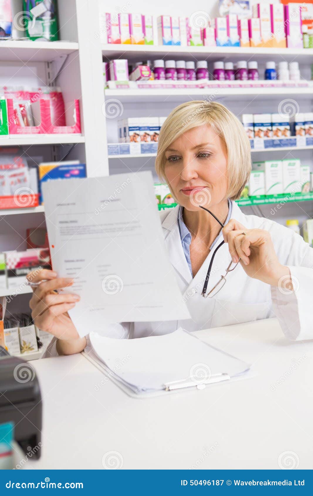 Smiling Pharmacist Thinking and Reading Prescription Stock Image ...