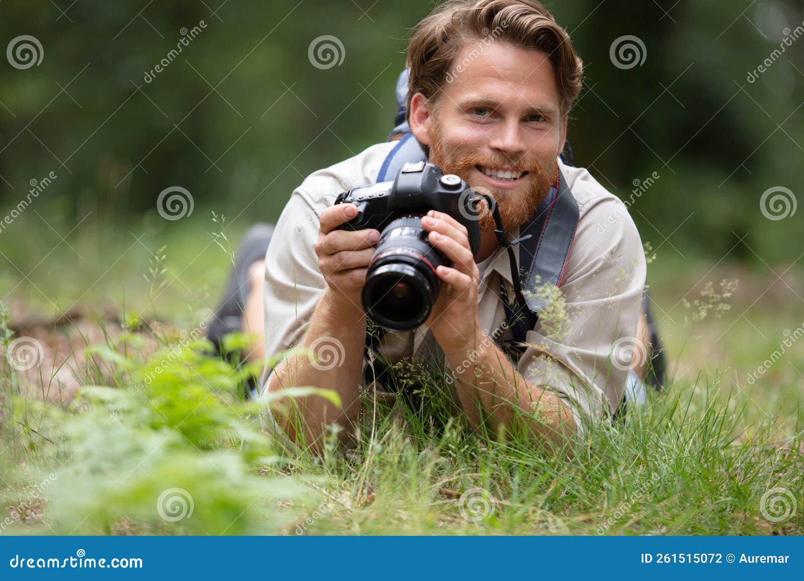 Smiling Photographer Laying on Grass with Camera Stock Photo - Image of ...