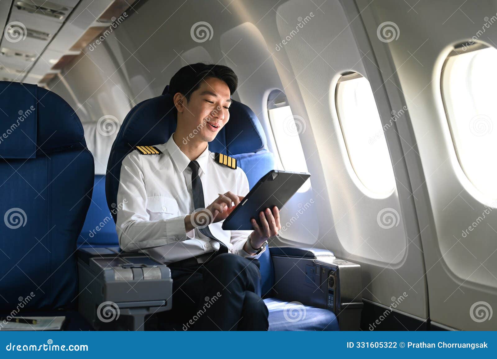 Smiling Pilot Checking Flight Plan or Preparing Flight Procedures in an ...