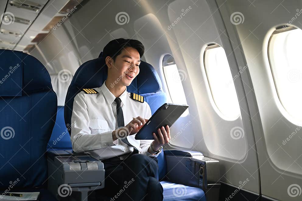 Smiling Pilot Checking Flight Plan or Preparing Flight Procedures in an ...
