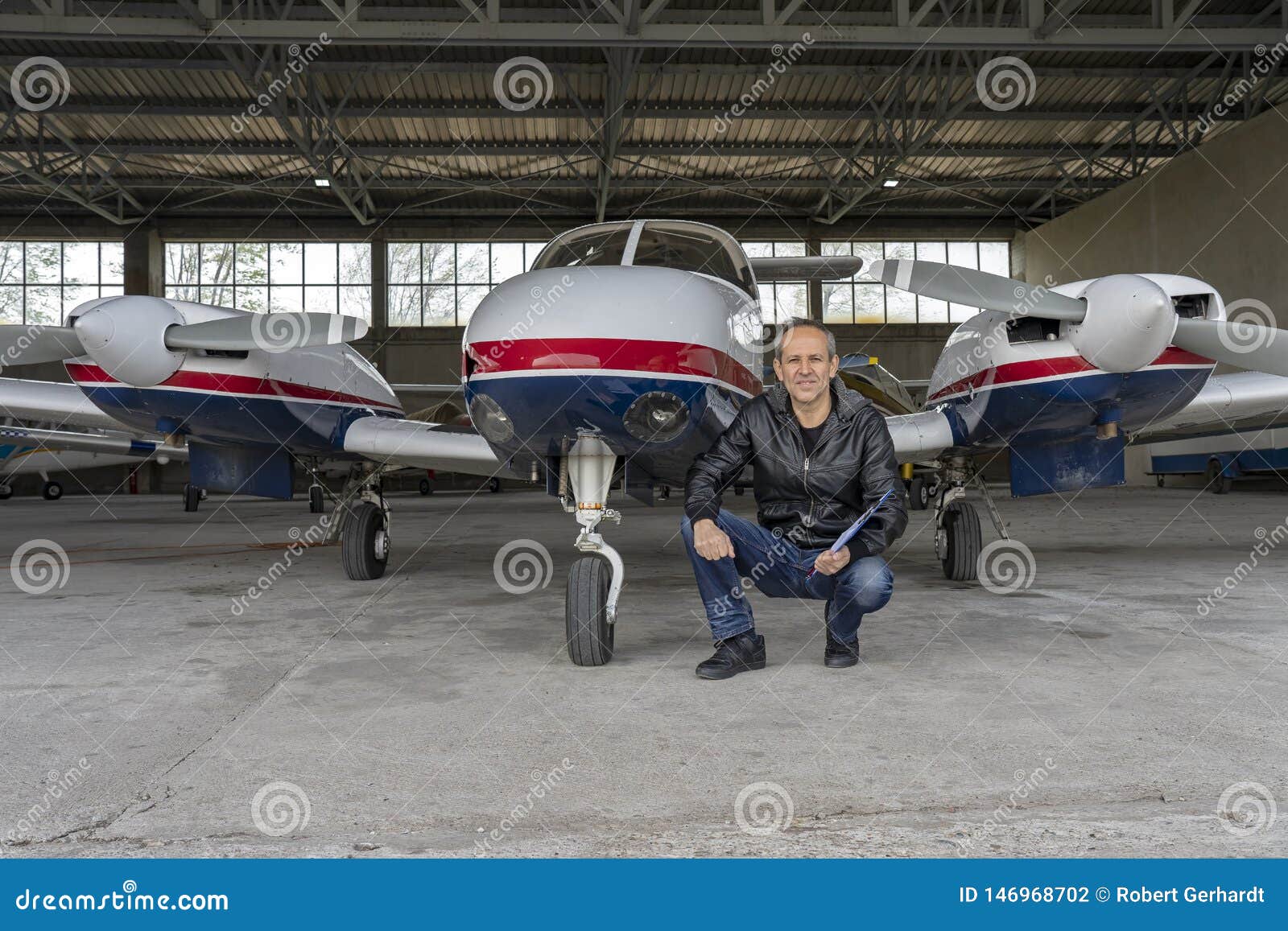 Smiling Pilot in Front of Modern Private Airplane in a Hangar Stock ...