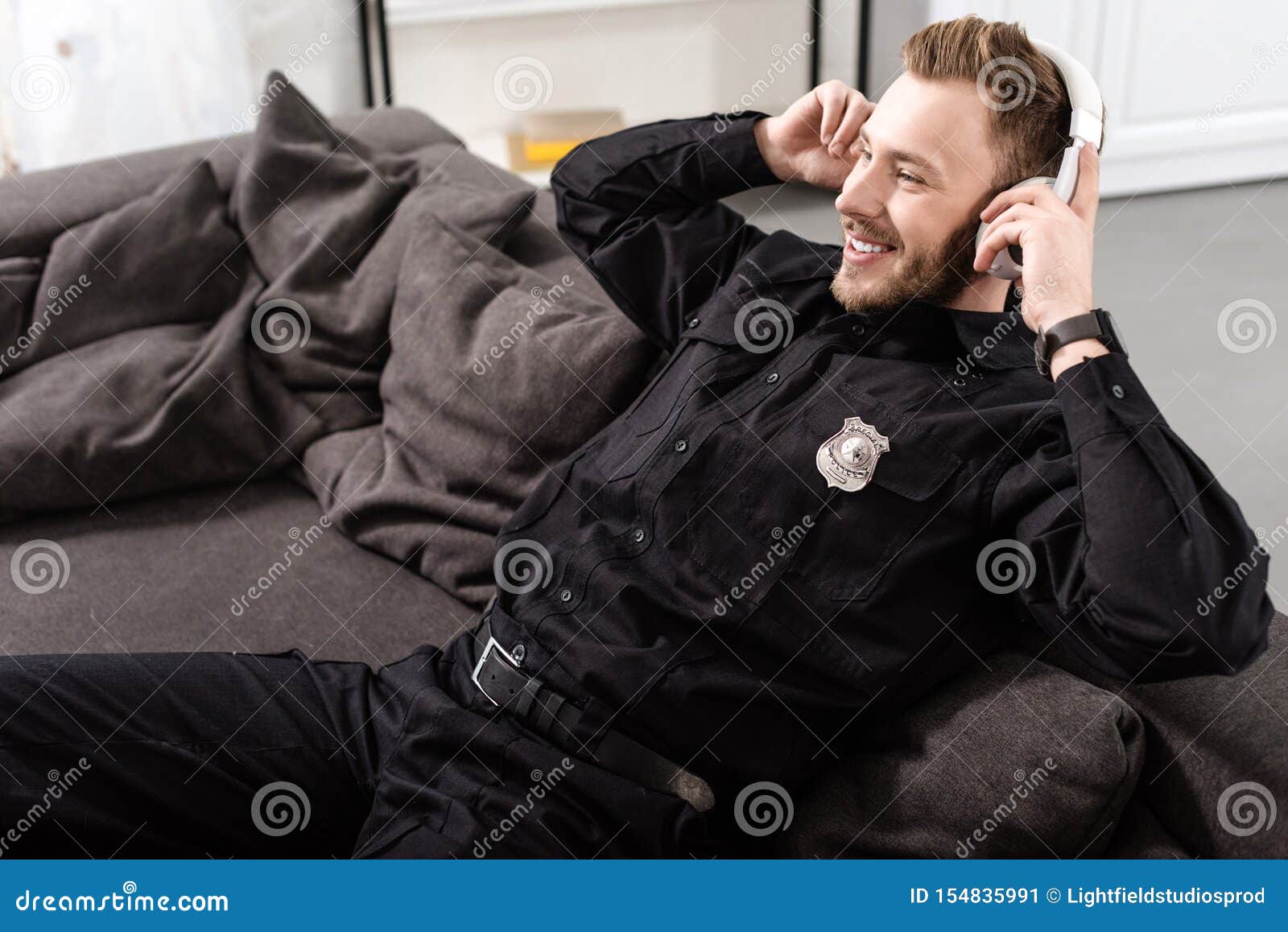Smiling Policeman Sitting on Couch and Putting Stock Image - Image of ...