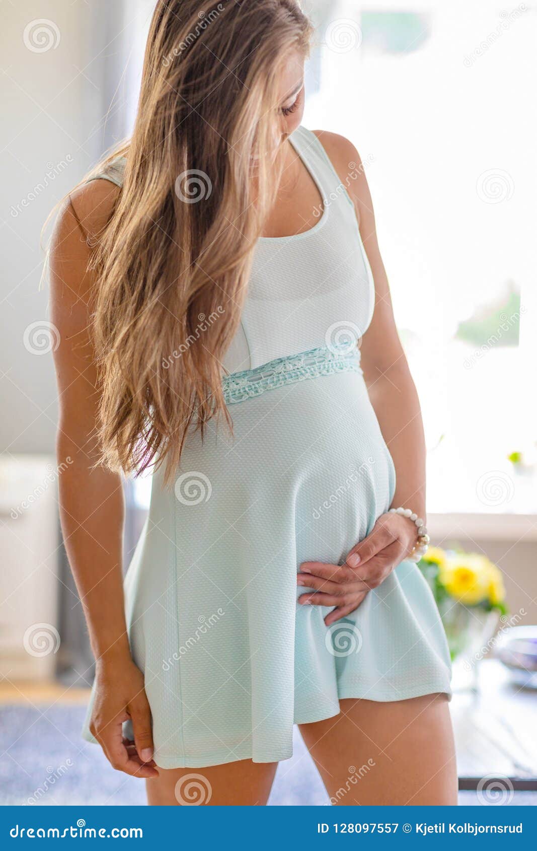 Smiling Pregnant Woman Standing With Her Hands At Belly Stock Image