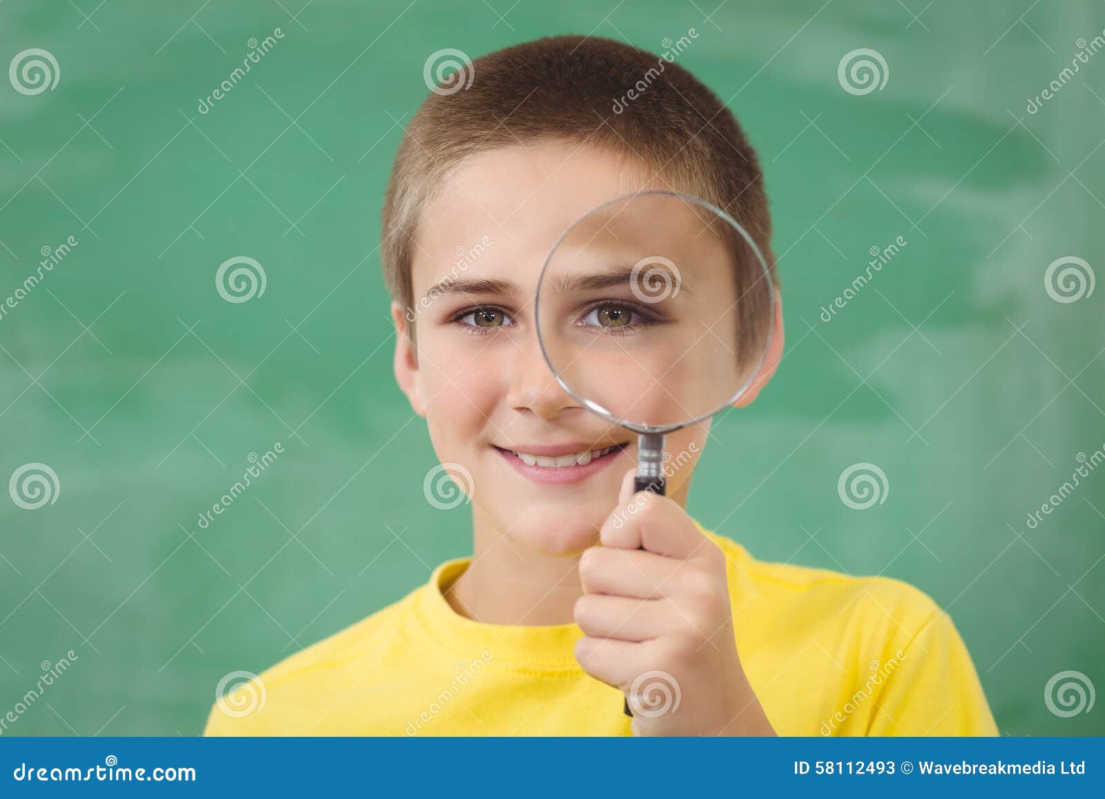 Smiling Pupil Looking through Magnifier in a Classroom Stock Image ...