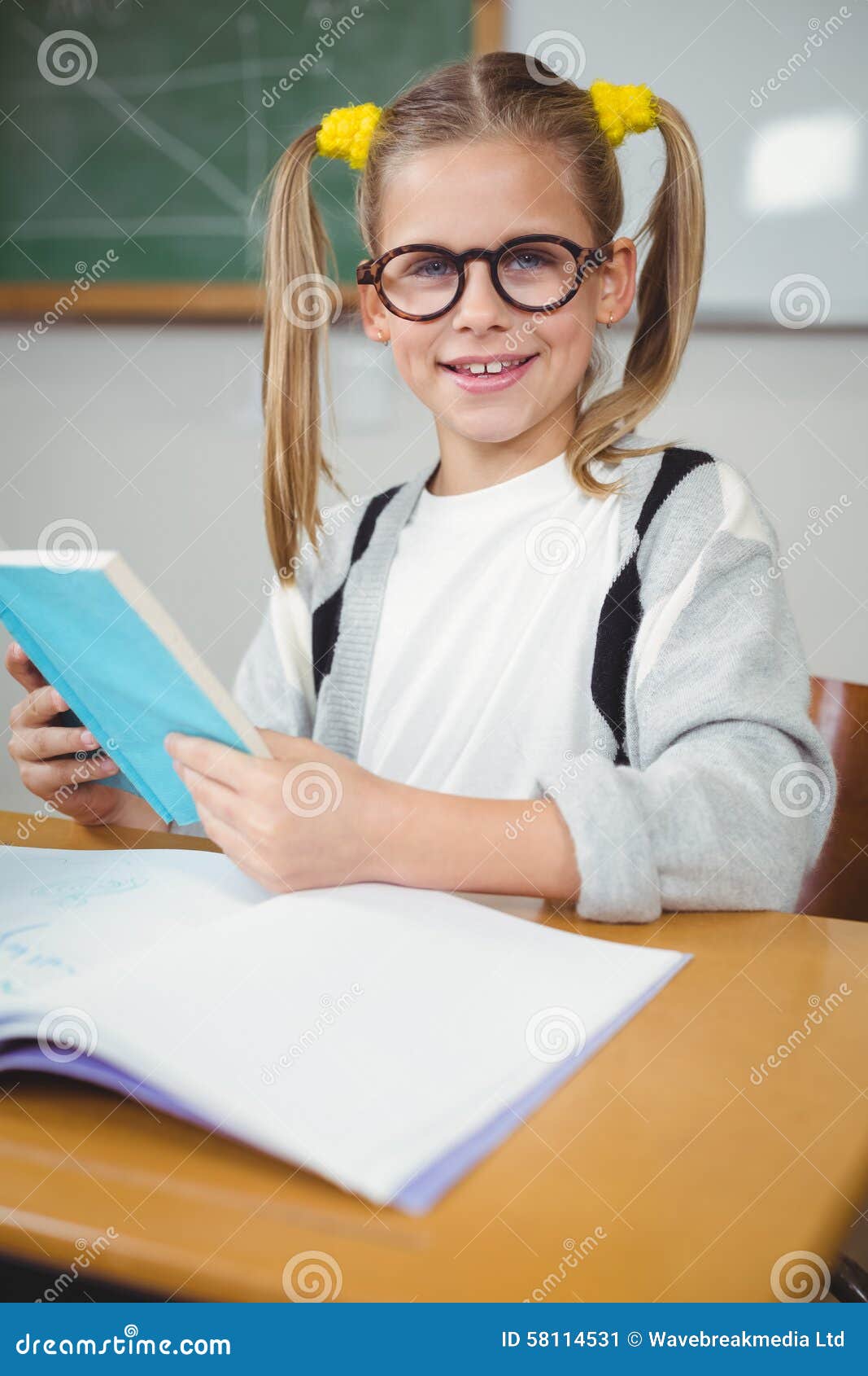 Smiling Pupil Reading Book at Her Desk Stock Image - Image of ...