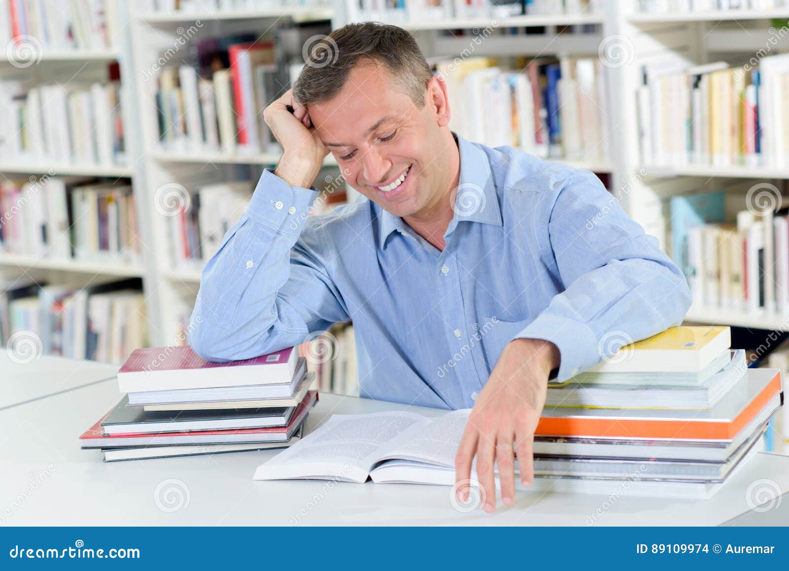 Smiling while reading book stock photo. Image of shelve - 89109974