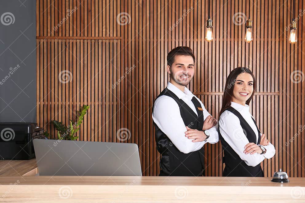 Smiling Receptionists at Desk Stock Photo - Image of computer, hotel ...