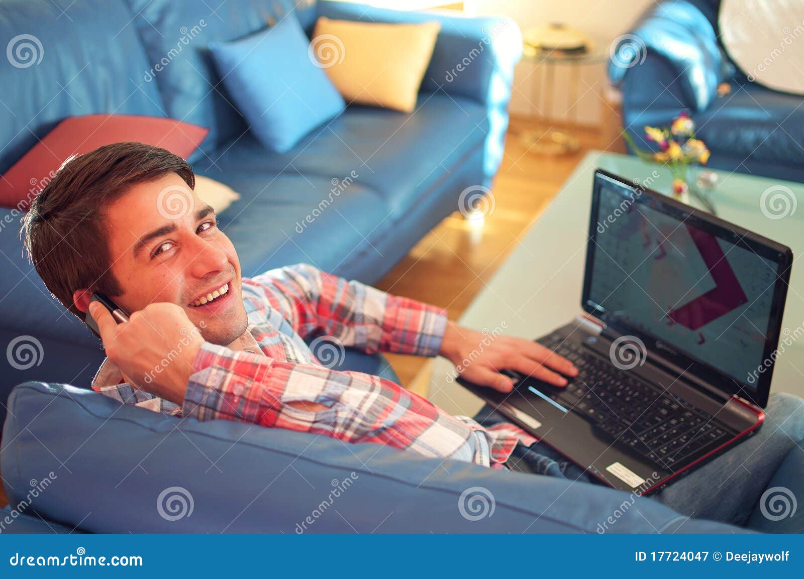 Smiling Relaxed Young Guy Using Laptop and Phone Stock Image - Image of ...