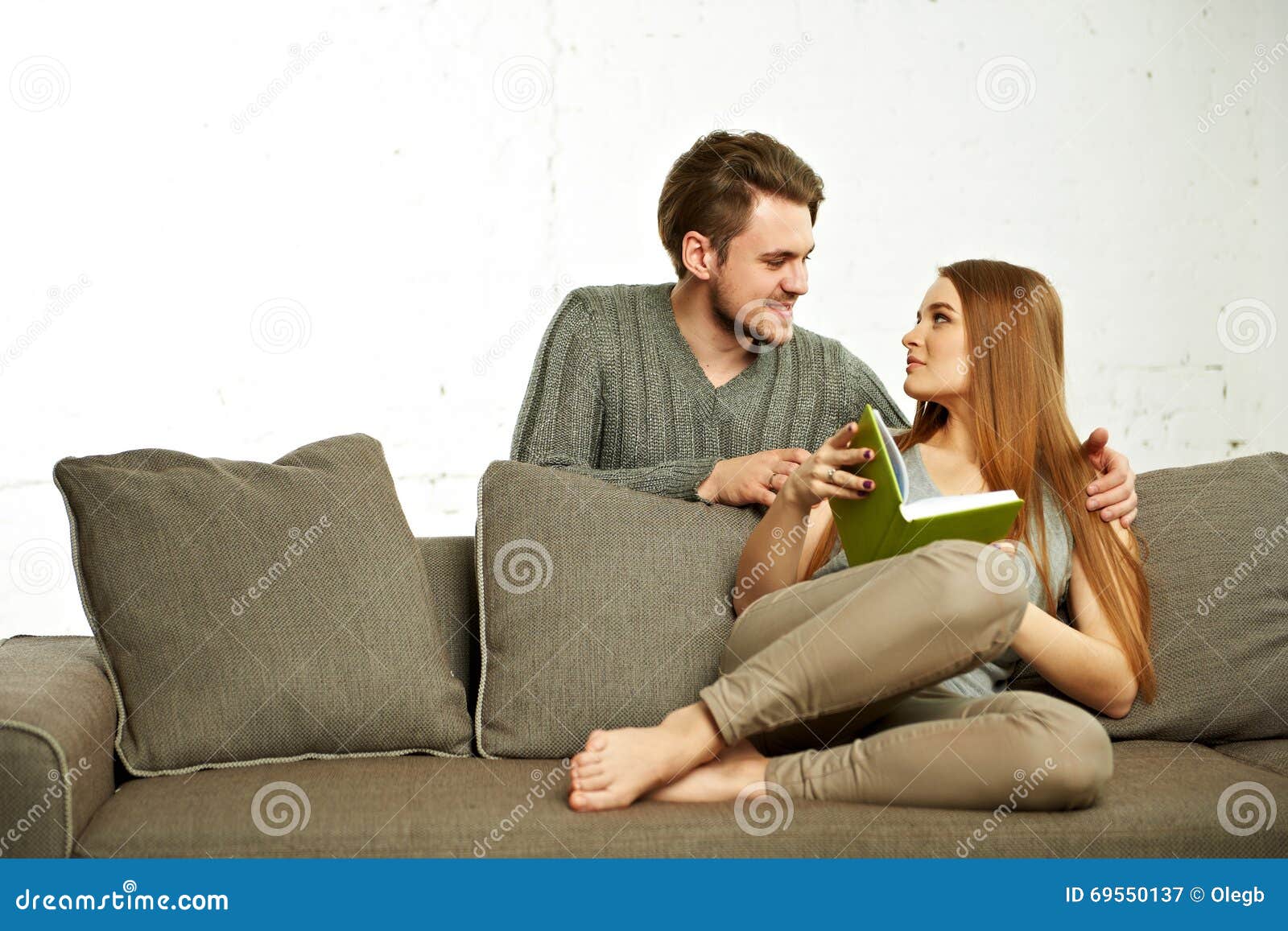 Smiling Romantic Couple With Book Talking On Sofa Stock Image Image