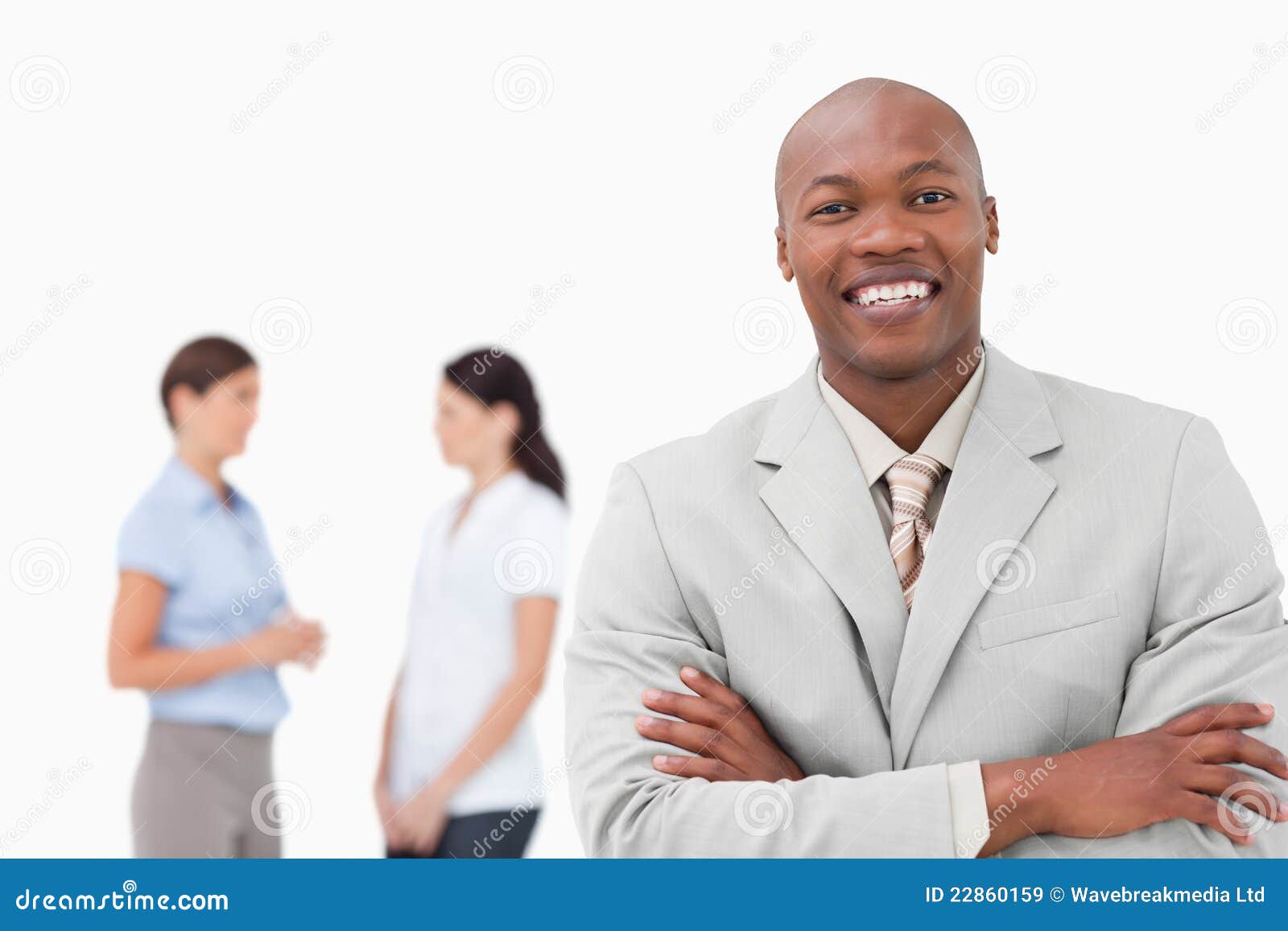 Smiling Salesman with Arms Folded and Associates Behind Him Stock Image ...