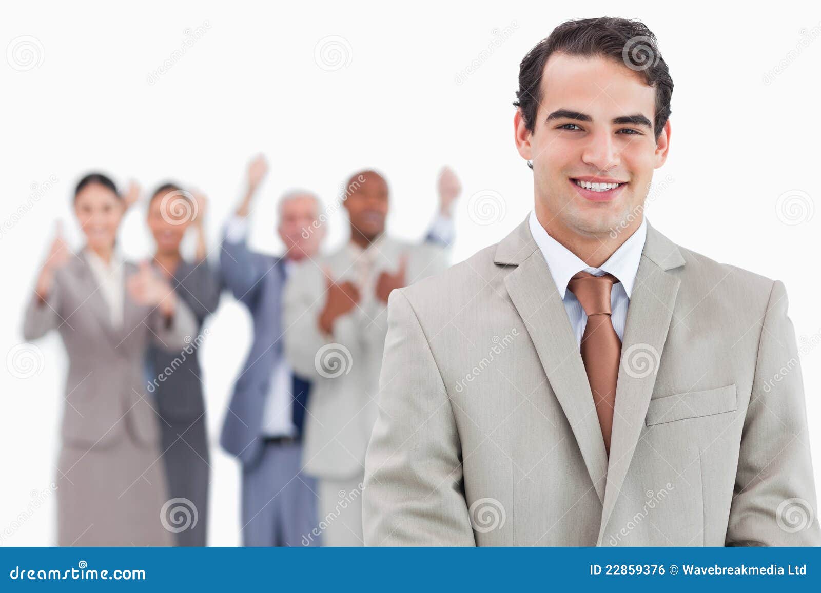 Smiling Salesman with Cheering Team Behind Him Stock Photo - Image of ...