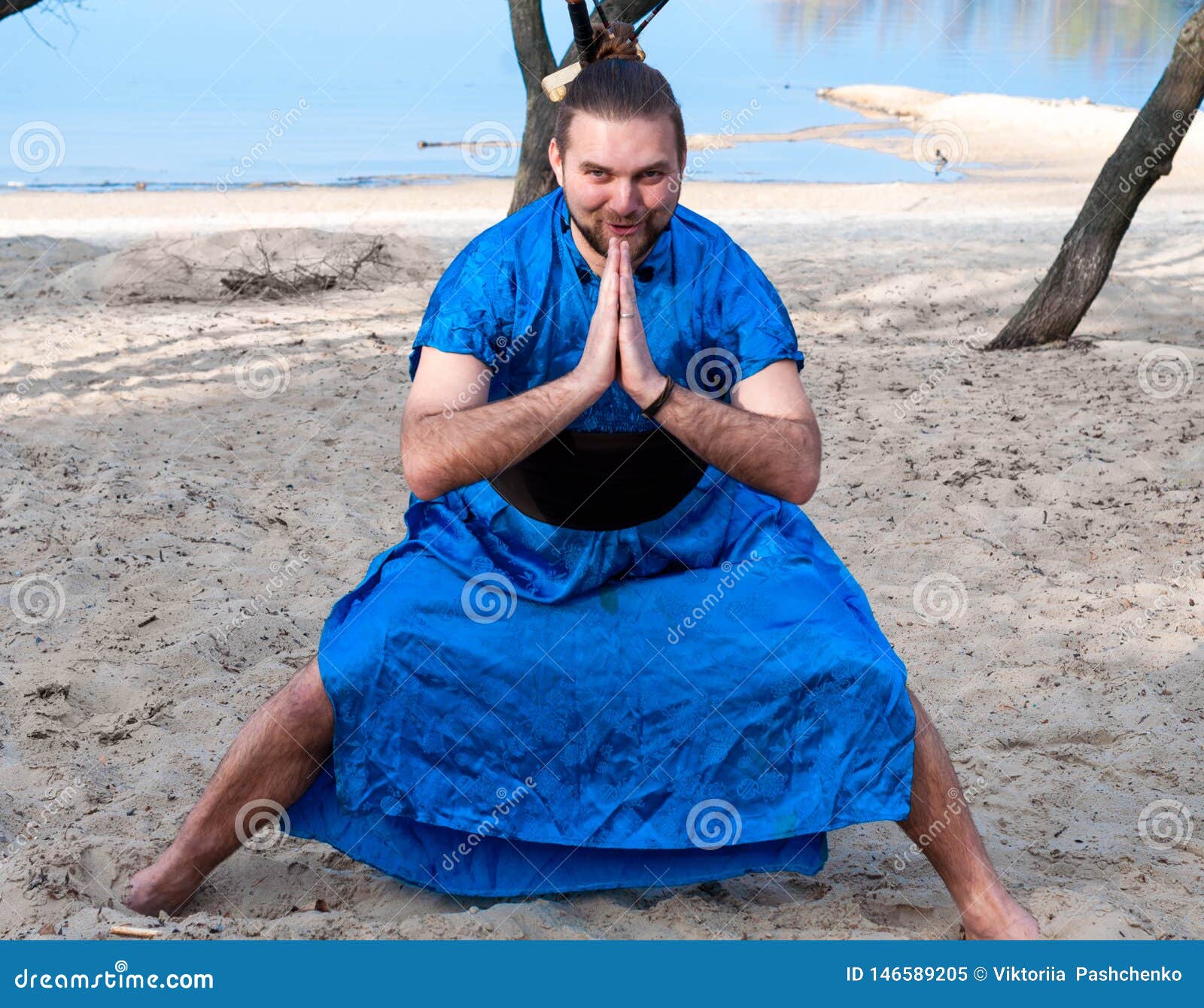 Smiling Samurai in Blue Kimono, Standing with Clasped Hands and Sword ...