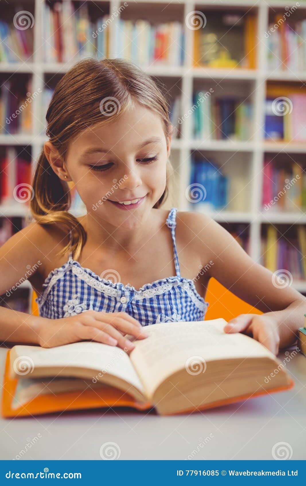 Smiling School Girl Reading a Book in Library Stock Image - Image of ...
