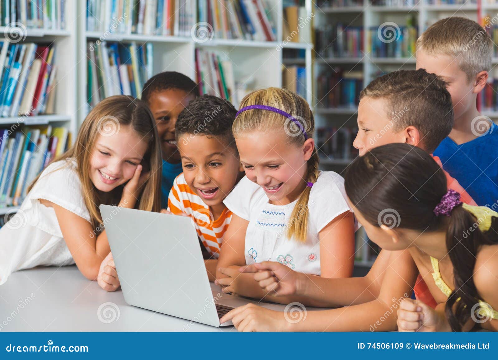 Smiling School Kids Looking at Laptop in Library Stock Image - Image of ...