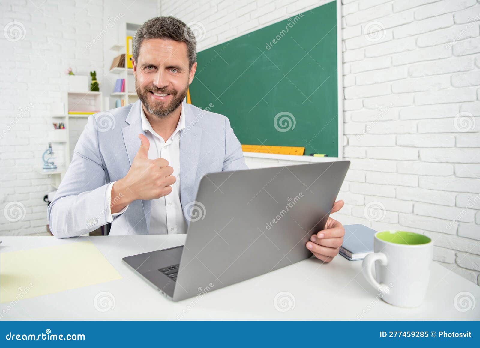 Smiling School Teacher in Classroom with Computer at Blackboard Stock ...