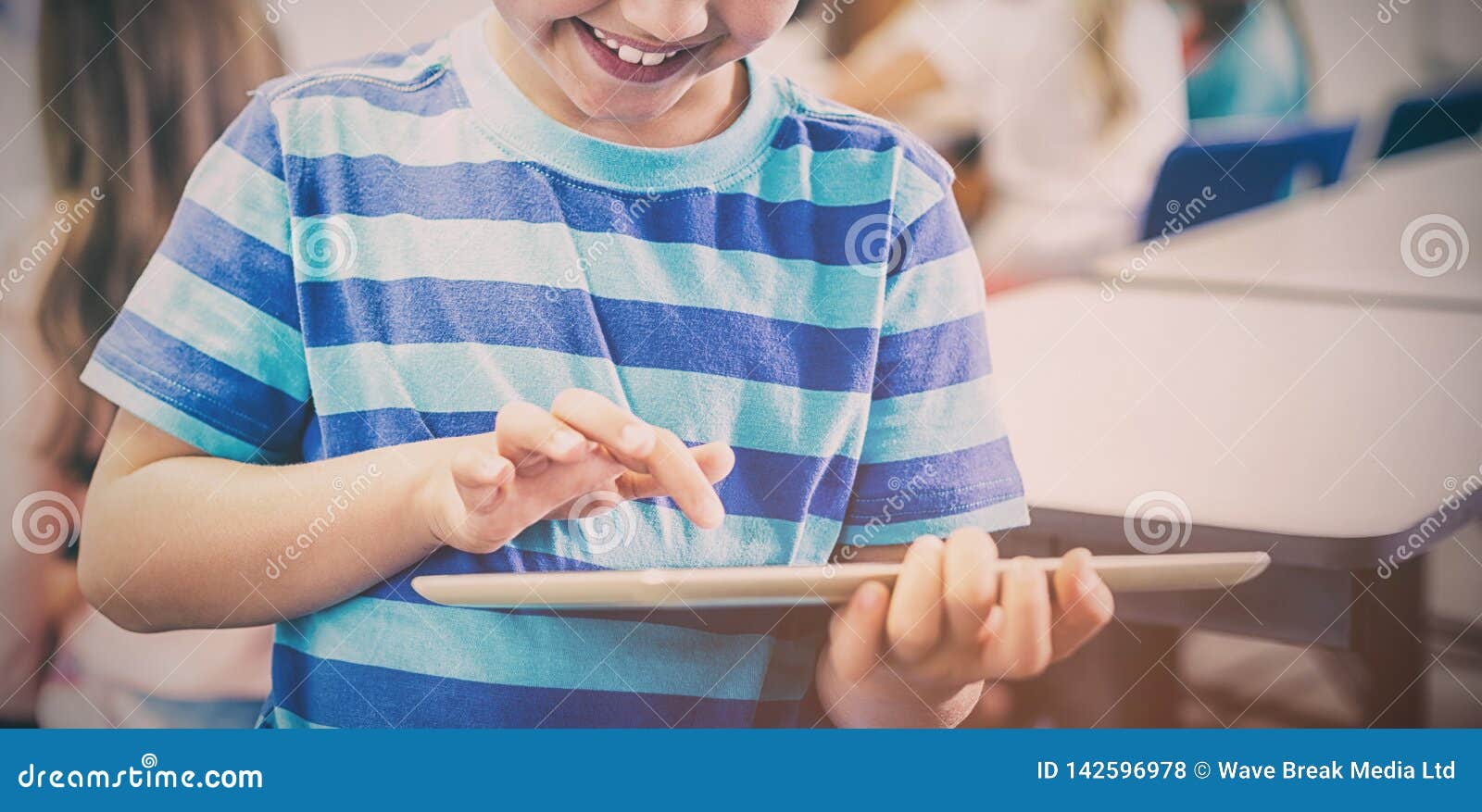 Smiling Schoolboy Using Digital Tablet in Classroom Stock Photo - Image ...