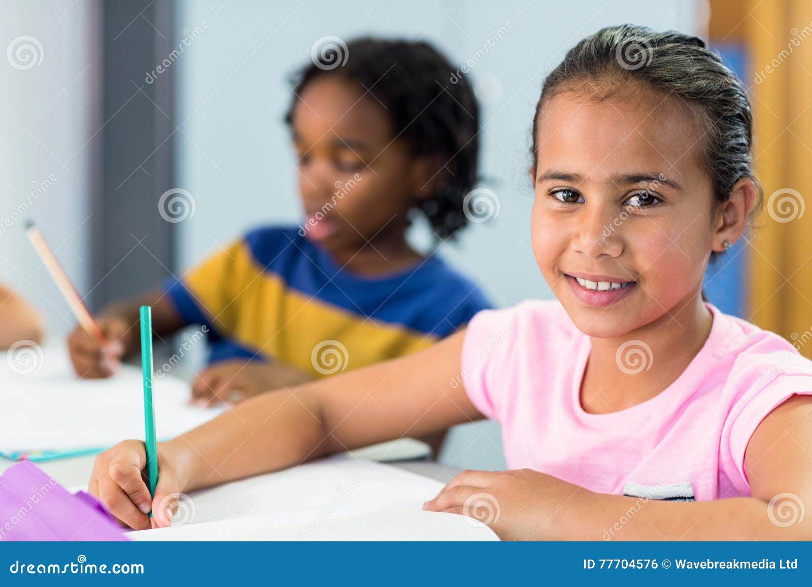 Smiling Schoolgirl with Classmate Writing on Book Stock Photo - Image ...