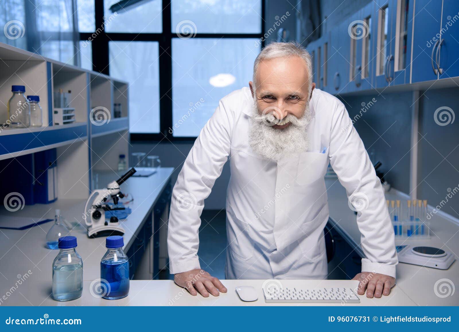 Smiling Scientist with Hands on Table Looking at Camera in Laboratory ...